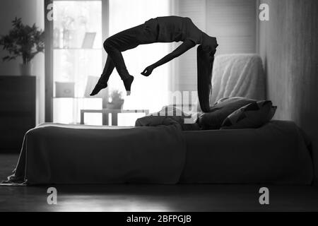 Sleep paralysis concept. Young woman levitating over bed Stock Photo ...