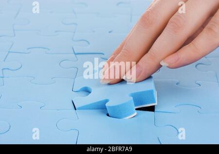 Hand collecting a part of a puzzle Stock Photo - Alamy