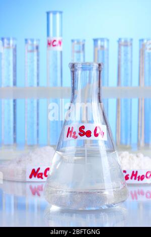 Test-tubes with various acids and chemicals on blue background Stock ...