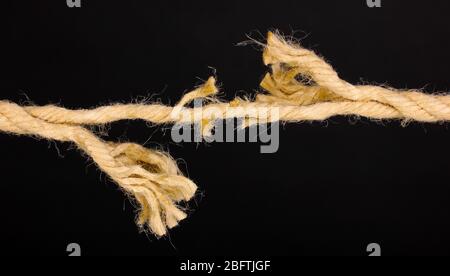 Breaking rope isolated on black background Stock Photo - Alamy