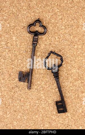Two antique keys on cork background Stock Photo - Alamy