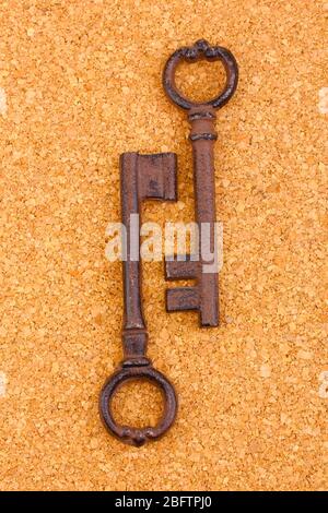Two antique keys on cork background Stock Photo - Alamy