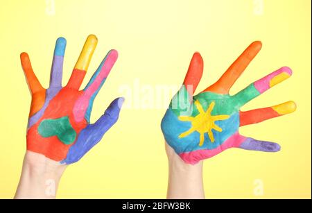 Brightly colored hands on yellow background close-up Stock Photo - Alamy