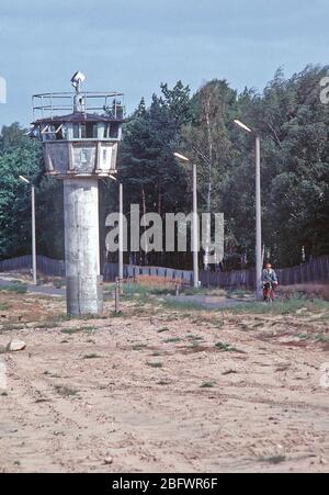 1/1/1990 - A cyclist passes an abandoned watchtower at the former ...
