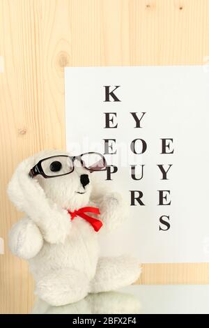 Eyesight test chart with glasses and with toy on wooden background ...