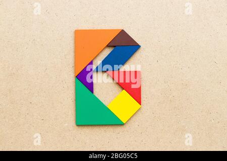 Tangram puzzle in alphabet letter S shape on wood background Stock ...