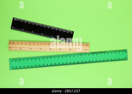Rulers on green background Stock Photo - Alamy