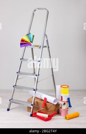Metal ladder and paint in room Stock Photo - Alamy
