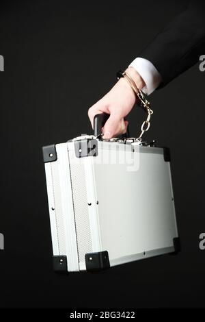 Hand with handcuff and suitcase, isolated on black Stock Photo - Alamy