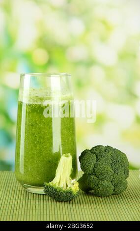 Glass of broccoli juice, on bamboo mat, on green background Stock Photo ...