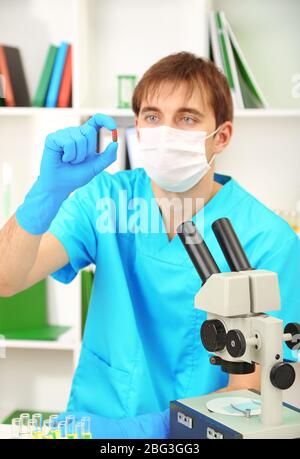 Assayer during research on room background Stock Photo - Alamy