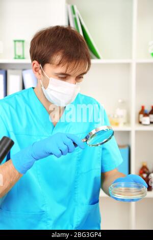 Assayer during research on laboratory background Stock Photo - Alamy