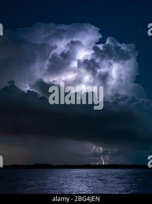 Lightning strike on the ocean at night Stock Photo - Alamy