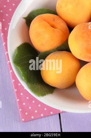 Apricots in plate on napkin on wooden table Stock Photo - Alamy