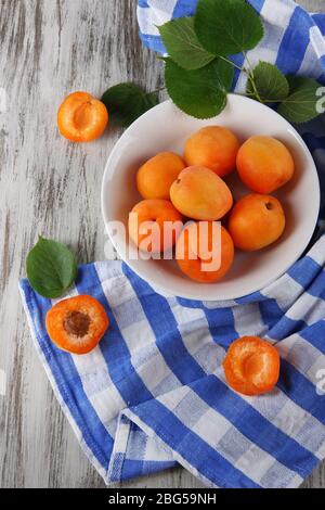 Apricots on board for cutting on napkin on wooden table Stock Photo - Alamy
