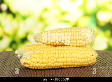 Fresh corn on bamboo mat, on bright background Stock Photo - Alamy