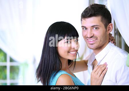 Beautiful young romantic couple near window Stock Photo - Alamy
