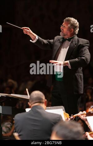 Conductor (model released) directs classical orchestra in performance ...