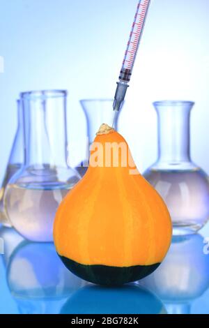 Injection into fresh pumpkin on blue background Stock Photo - Alamy