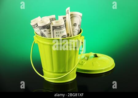 Money in the trash can on an orange background. Euros in the trash ...