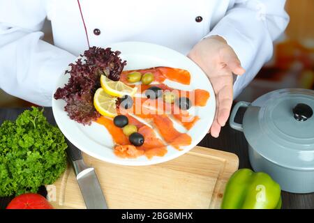 Cook hands holding dish at workplace Stock Photo - Alamy