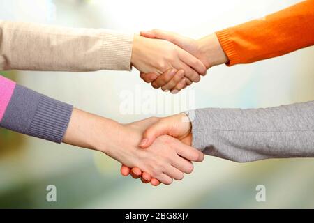 Handshakes on bright background Stock Photo - Alamy
