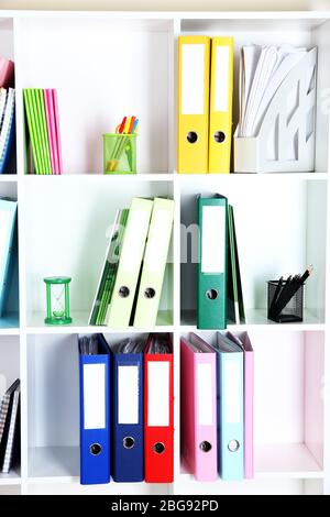 White office shelves with folders and different stationery, close up ...
