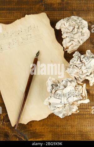 Crumpled paper balls with music sheet and clarinet on wooden background ...