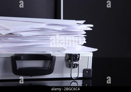 Briefcase full of papers, isolated on black Stock Photo - Alamy