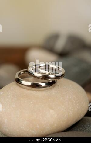 Wedding rings on rocks on bright background Stock Photo - Alamy