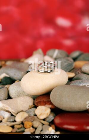 Wedding rings on rocks on bright background Stock Photo - Alamy