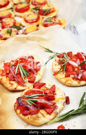 Small pizzas on baking paper close up Stock Photo - Alamy