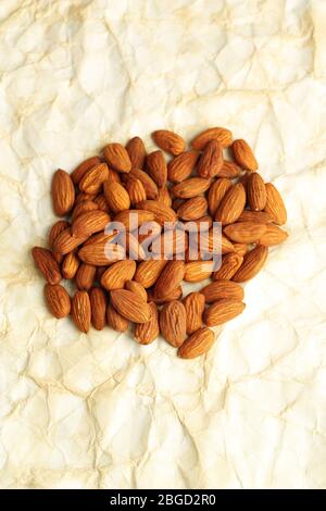 Almonds on old paper background Stock Photo - Alamy