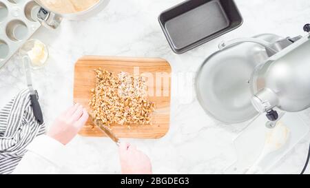 Step by step. Chopping walnuts with kitchen knife on a wood cutting ...