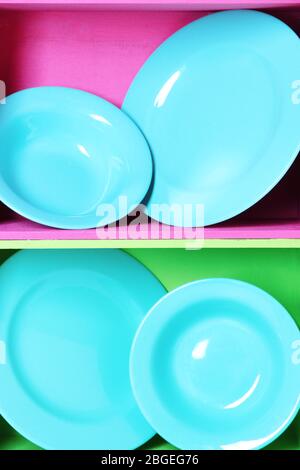 Beautiful bright shelves and boxes with tableware on light wall ...