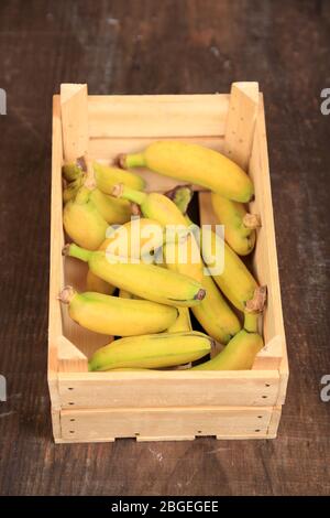 Bunch of mini bananas in wooden box isolated on white Stock Photo - Alamy