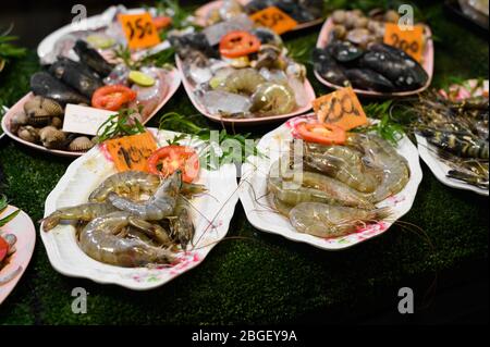 Fresh raw giant tiger prawns on beige plate with lemongrass, ginger ...