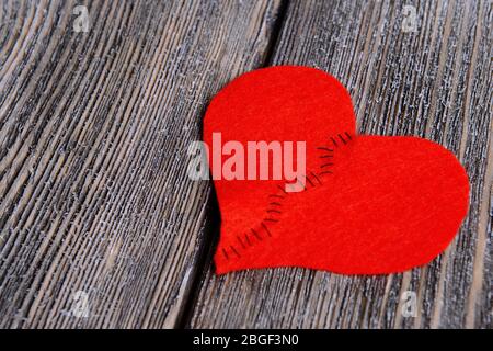 Broken heart and thread on wooden background Stock Photo - Alamy