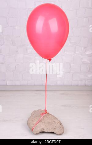 Color balloon with stone on grey wall background Stock Photo - Alamy