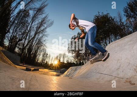 Skateboarder on wall turn at sunset at the local skatepark Stock Photo ...
