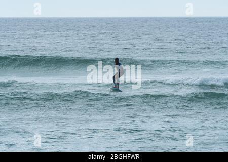 A middle aged man doing some foil surfing or hydrofoil surfing in the ...