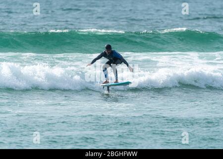 A middle aged man doing some foil surfing or hydrofoil surfing in the ...
