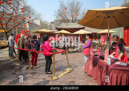People line up to get coupons at Yongxing Fang in Xi'an city, central ...