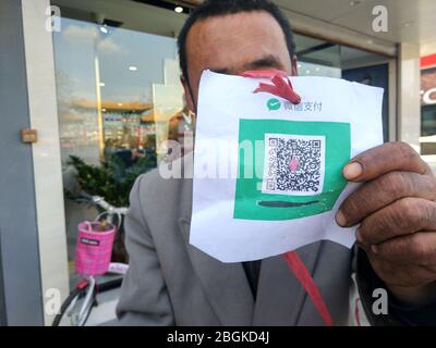 --FILE--A beggar, with a broken bowl full of coins and change in one ...