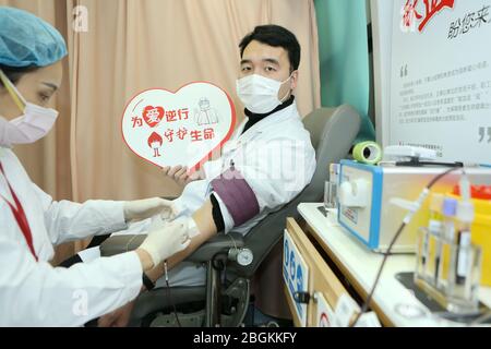 A donator gives out blood for saving lives at a bloodmobile, Shanghai ...