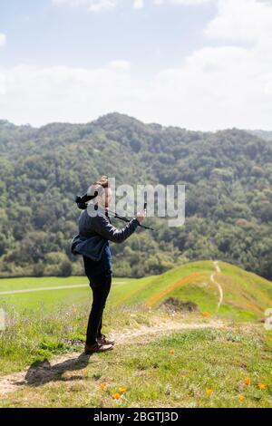 a young person takes a photo with a digital SLR camera with an old lens ...