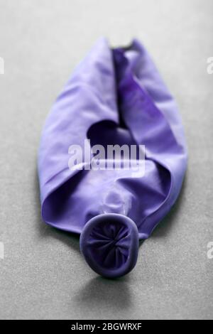 Popped violet balloon on paper background Stock Photo - Alamy