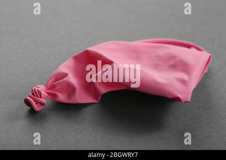 Popped pink balloon on paper background Stock Photo - Alamy