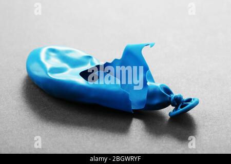 Popped blue balloon on paper background Stock Photo - Alamy