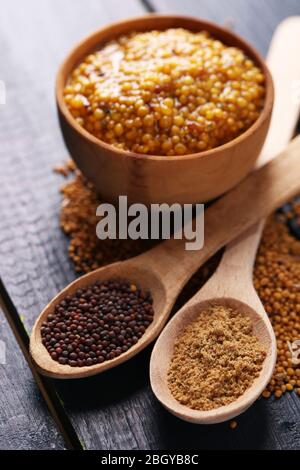 Composition of different kinds of mustard on color wooden background ...